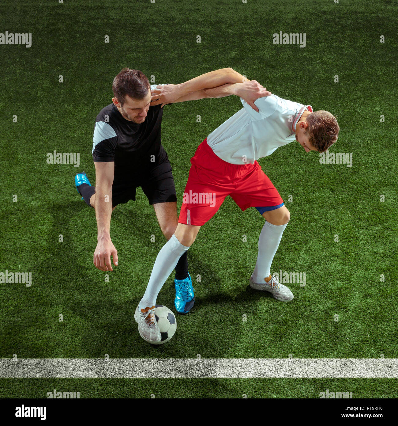 Football player tackling for ball over green grass background ...