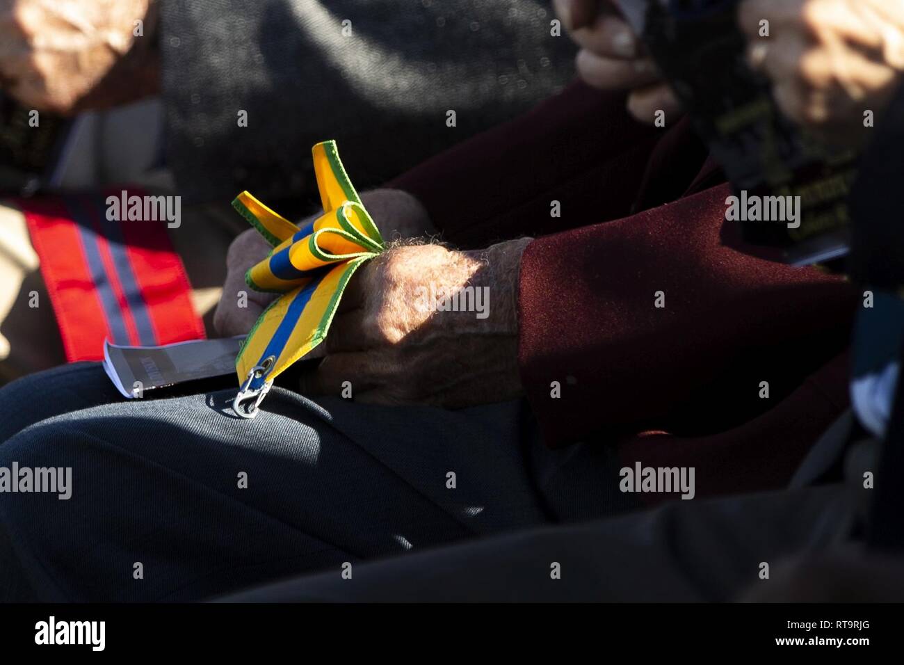 A 1st Marine Division veteran, holds a streamer during the 1st MARDIV ...