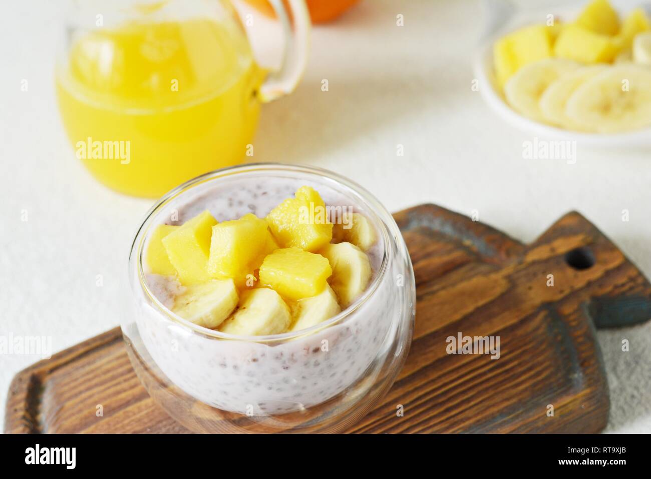 Chia pudding with mango pulp in beautiful glasses with green mint ...