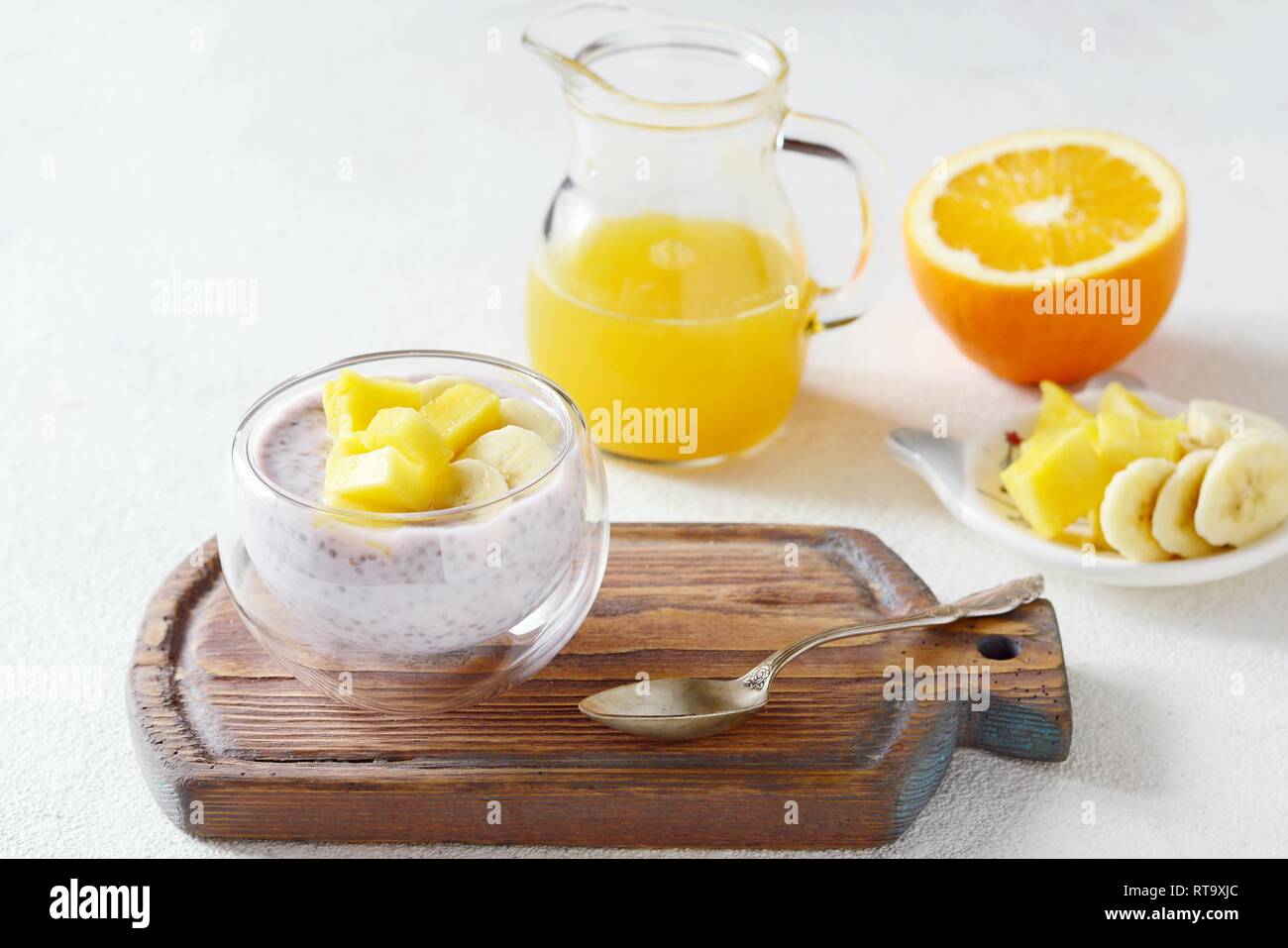 Chia pudding with mango pulp in beautiful glasses with green mint ...