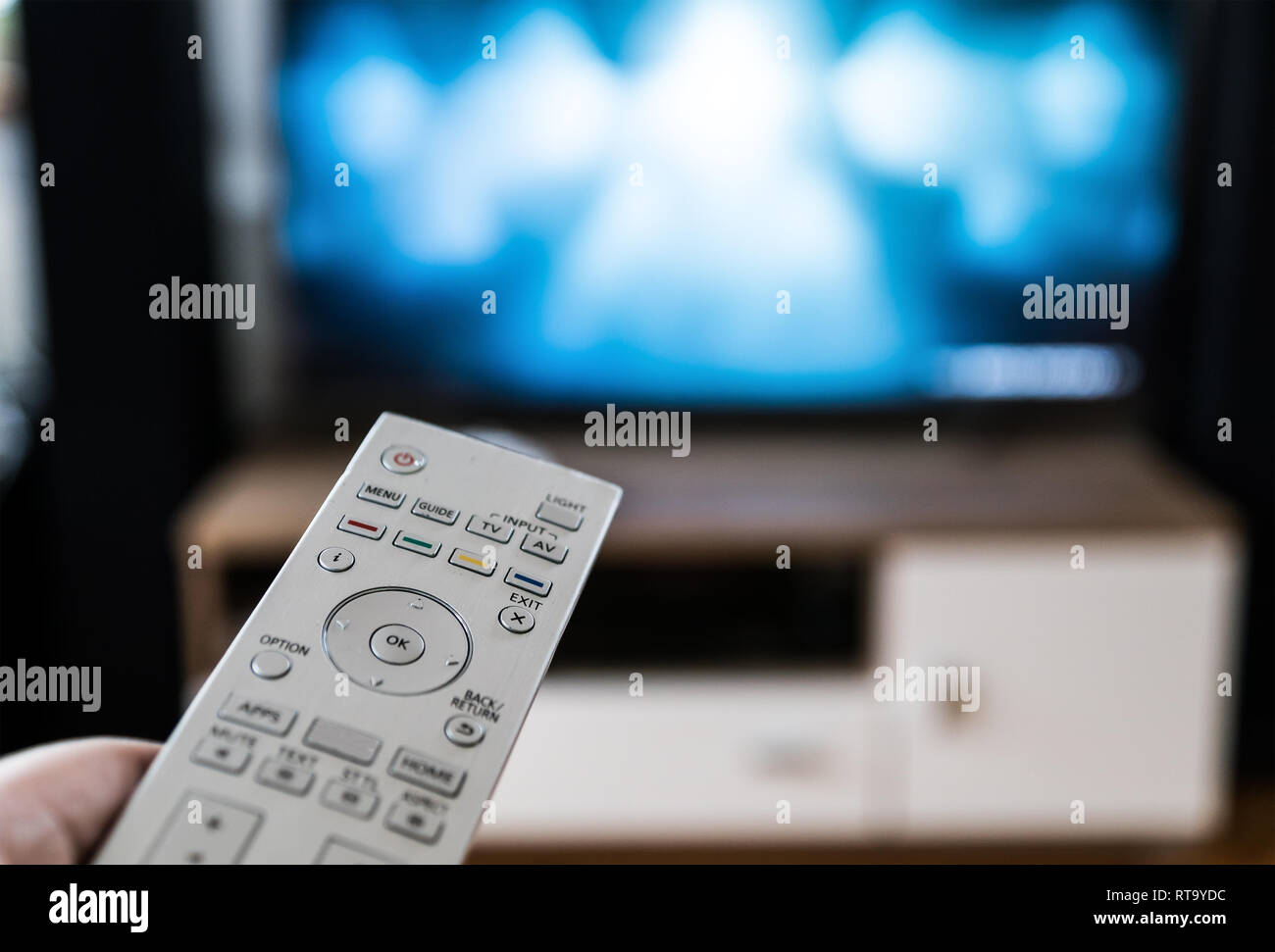 The man with the remote control in hand watching tv Stock Photo - Alamy
