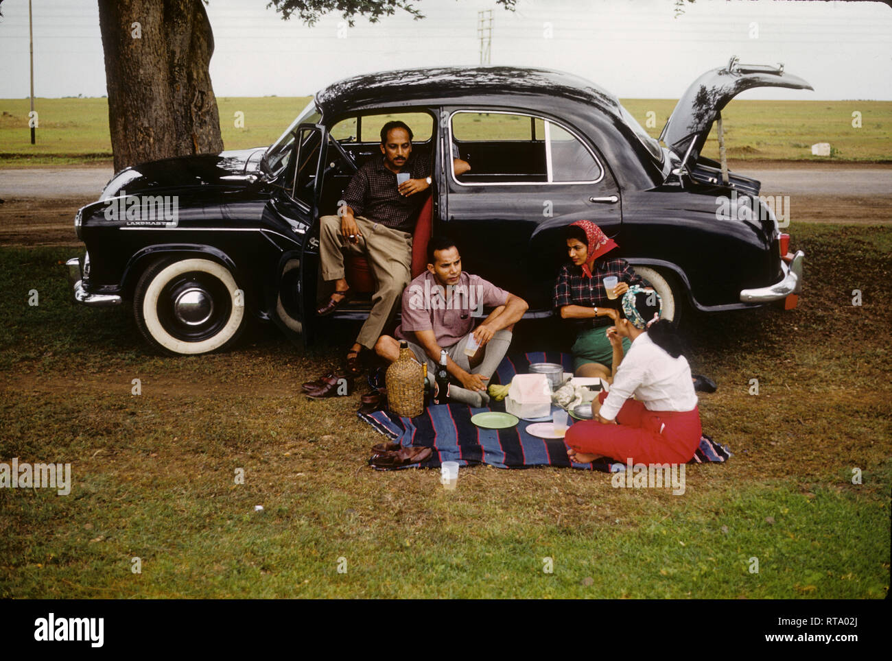 People having a picnic with Hindustan Landmaster car in India 1957 ...