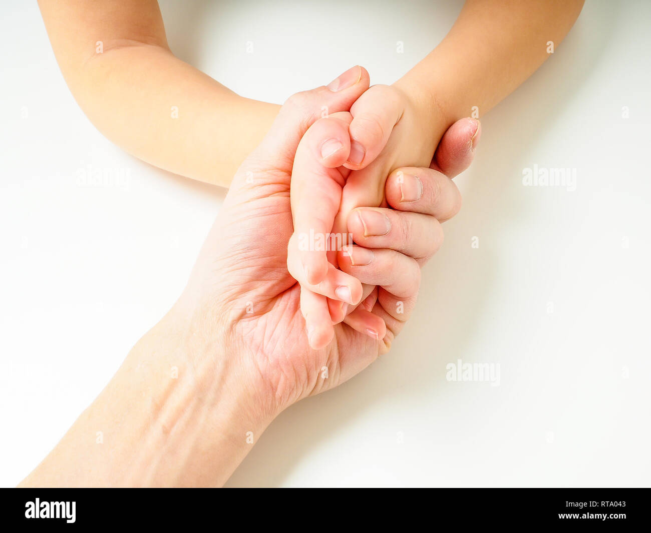 Toddlers hands in fathers hand, towards, on a white table Stock Photo ...