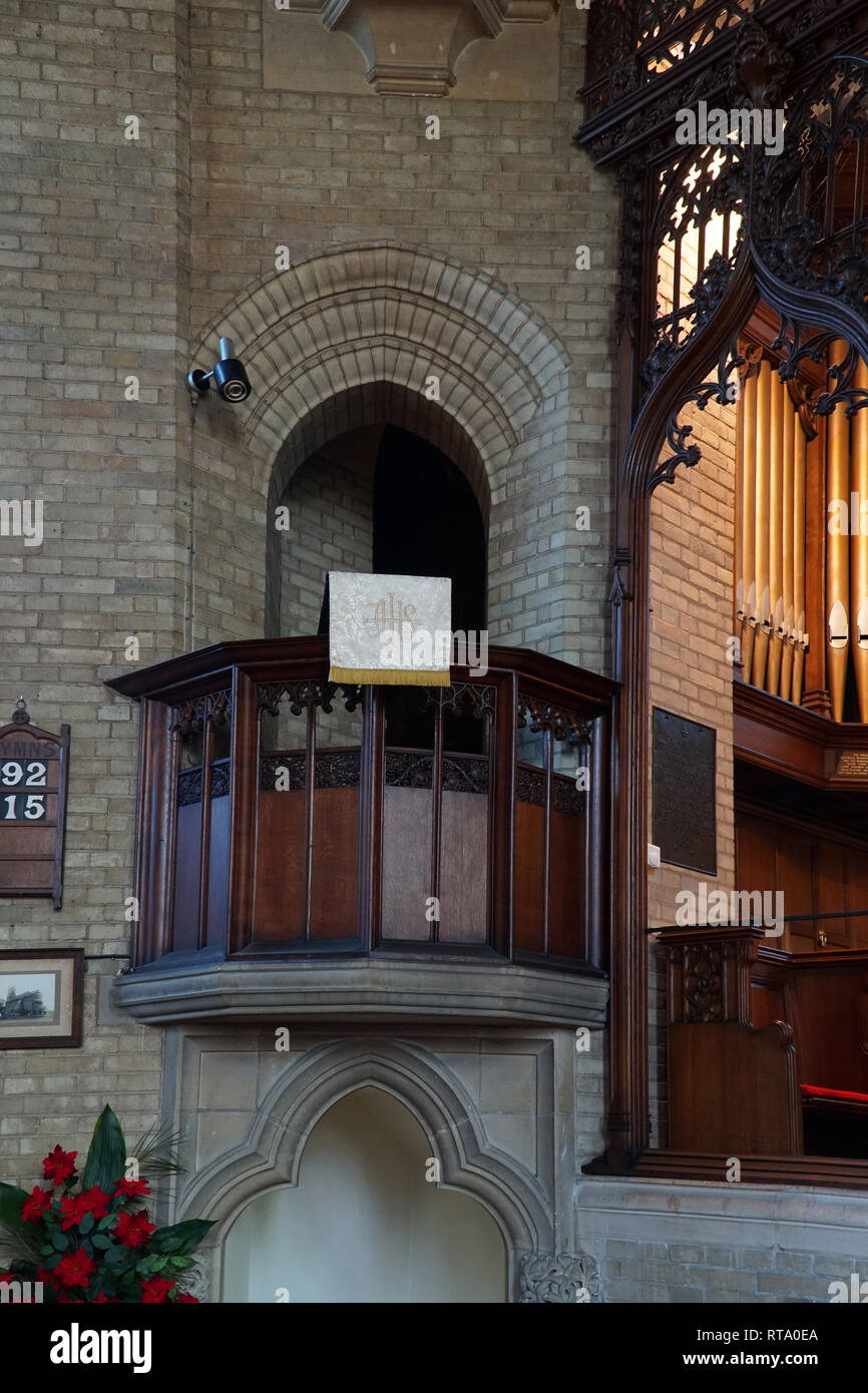 Interior of a Victorian church in the UK with oak pulpit and stone arch ...