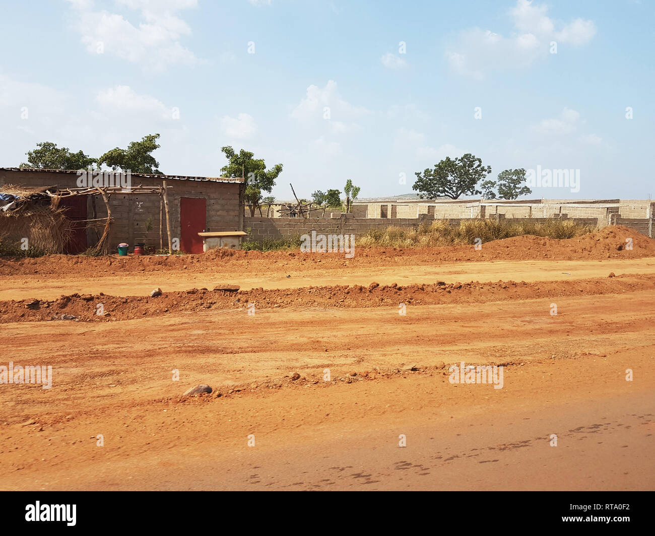Generic poor street of Bamako, Mali with small houses near the red ...