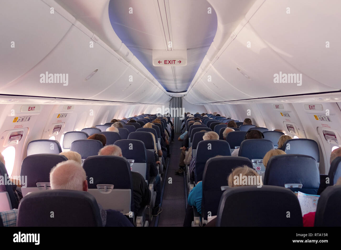 Interior of a plane with passengers on their seats Stock Photo - Alamy