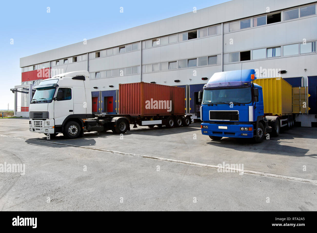 Unloading big container trucks at warehouse building Stock Photo - Alamy