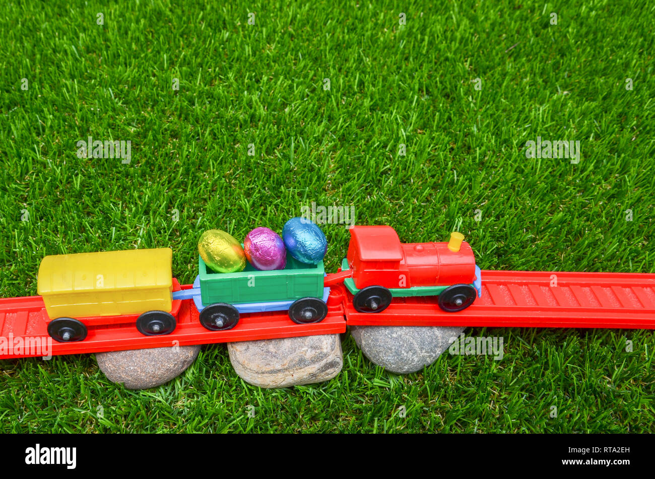 Easter eggs being transport via colour plastic toy train on railway ...
