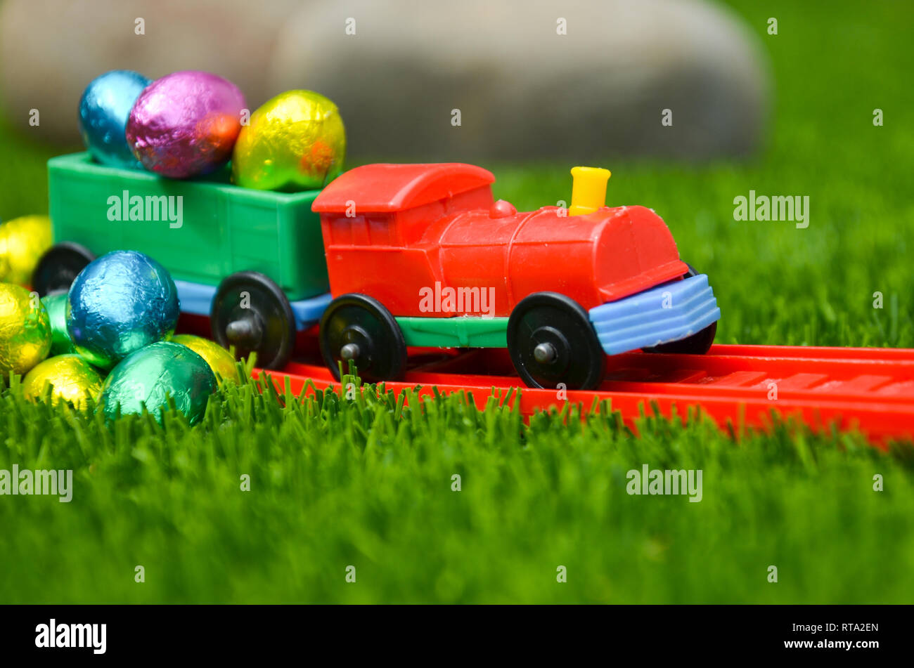 Plastic toy train with load of Easter Eggs in outdoors lawn scene ...
