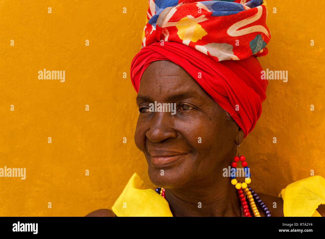 Portrait of a beautiful woman against yellow background in Cartagena ...