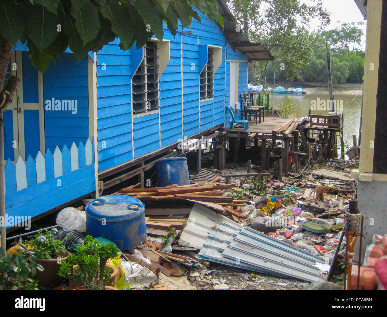 Traditional riverside kampung (village) house surrounded by rubbish in ...