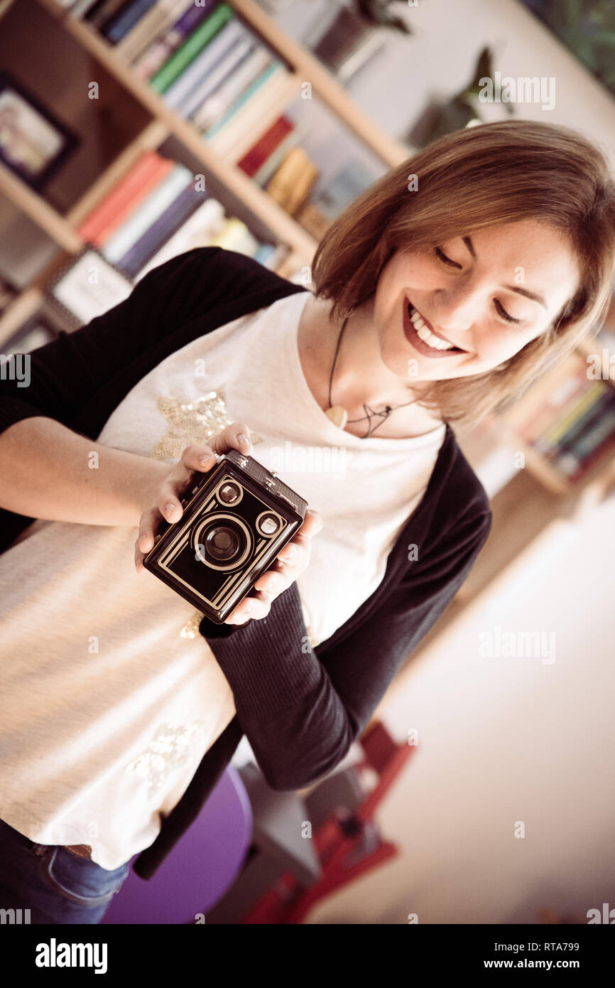Loughing girl is making a picture with a vintage camera Stock Photo - Alamy