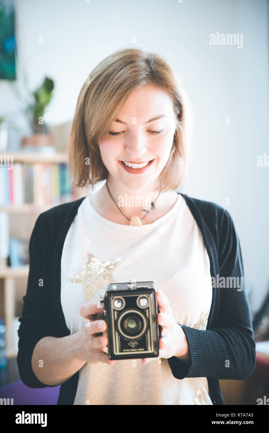 Loughing girl is making a picture with a vintage camera Stock Photo - Alamy