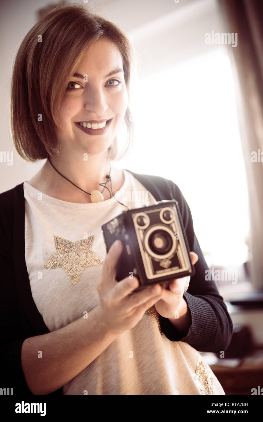 Loughing girl is making a picture with a vintage camera Stock Photo - Alamy