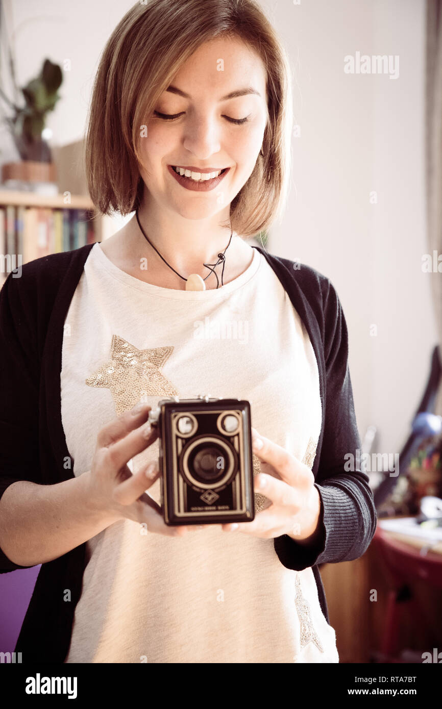 Loughing girl is making a picture with a vintage camera Stock Photo - Alamy