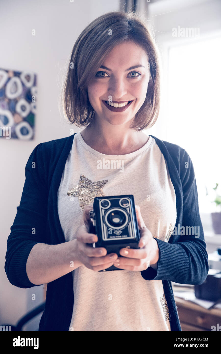 Loughing girl is making a picture with a vintage camera Stock Photo - Alamy