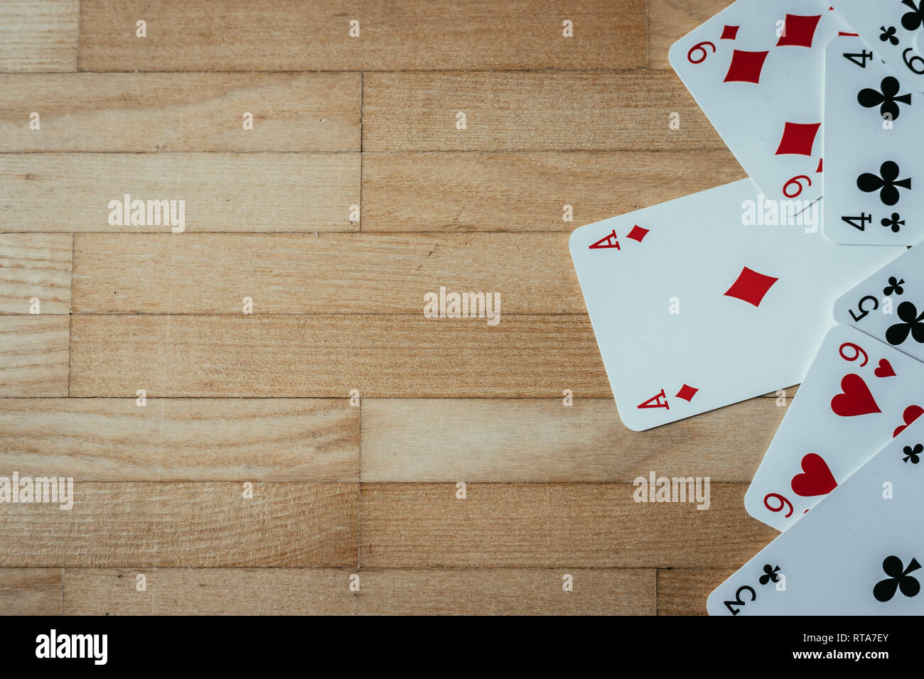 Gaming cards are lying on wood table. Playing cards at home, copy space ...