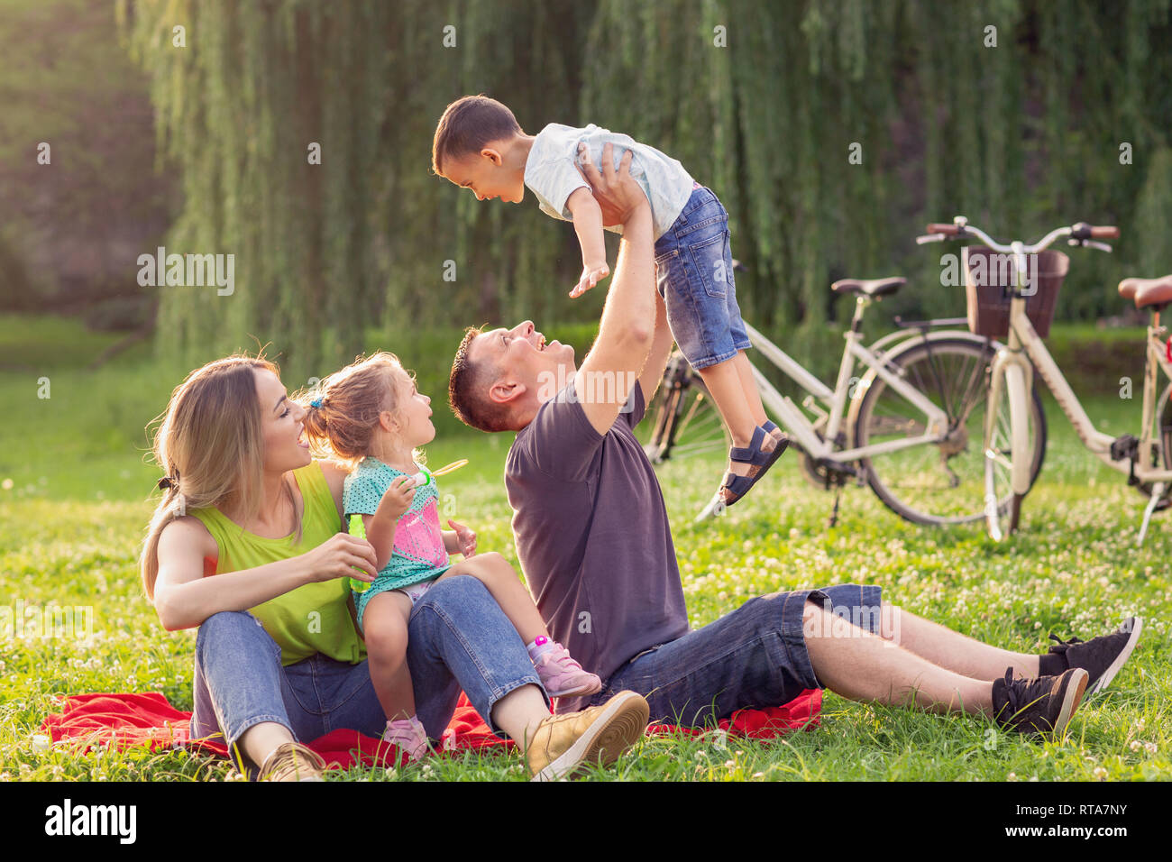 Happy Childhood – Smiling father raising his boy up Stock Photo - Alamy