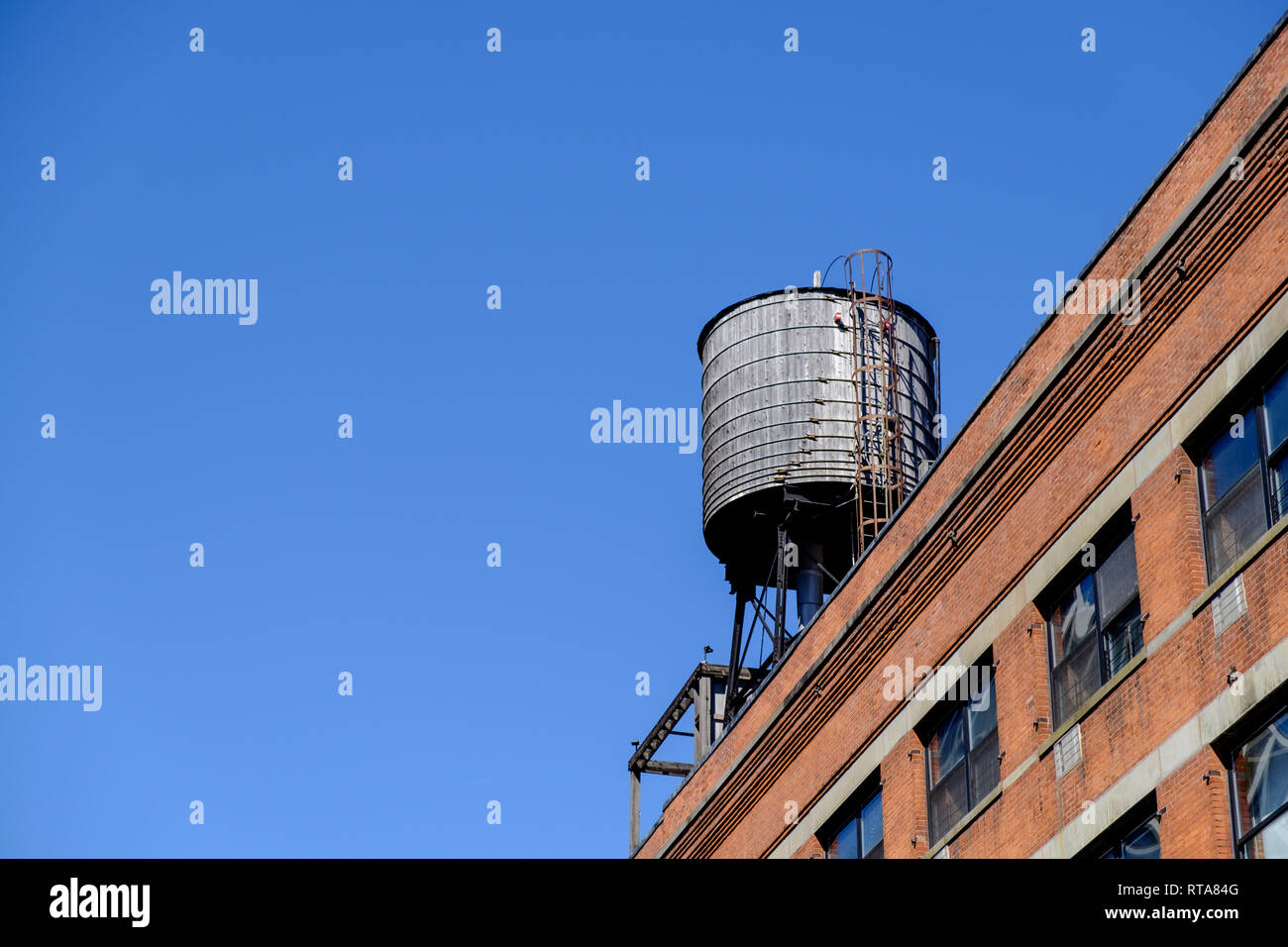 Old round water tower on the top of a building in Chelsea, New York ...