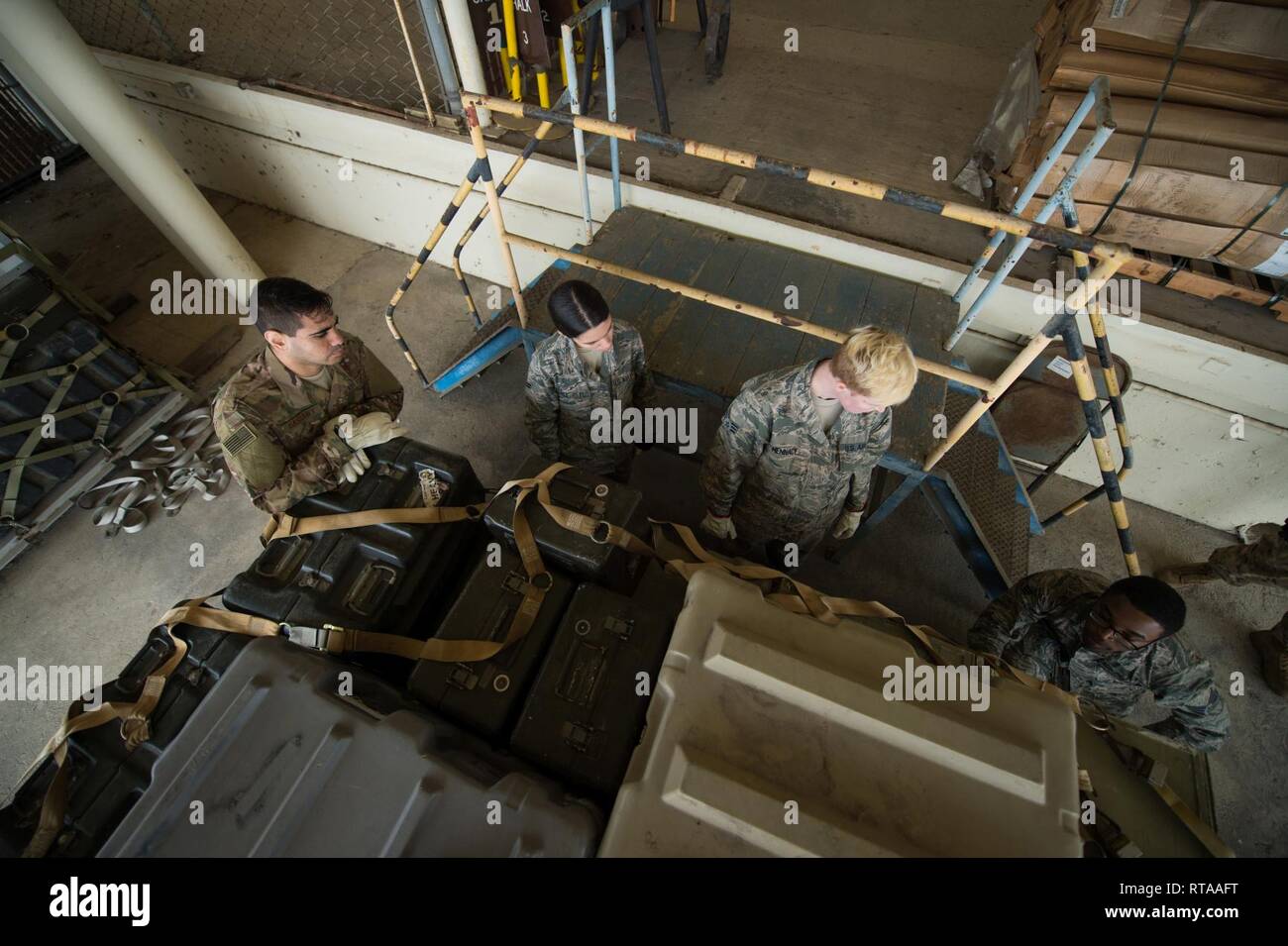 U.S. Air Force Airmen secure straps during cargo prep pallet build up ...