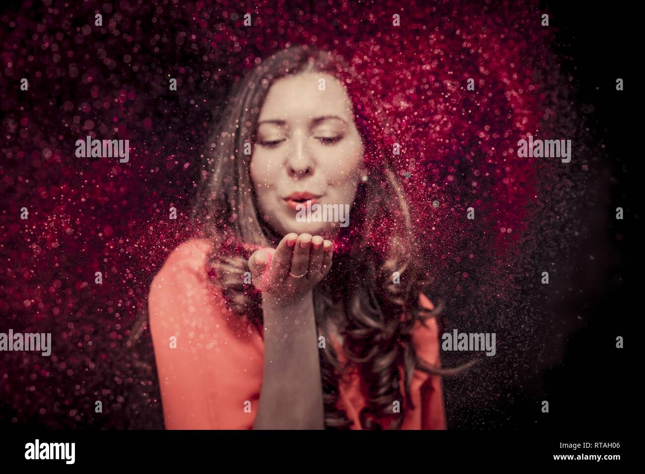 Girl blowing colored glitter from her hand Stock Photo - Alamy