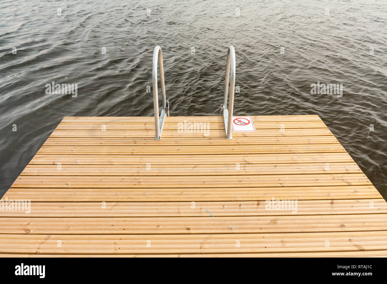 Metal stairs of a wooden pier into lake water at autumn sunny day Stock ...