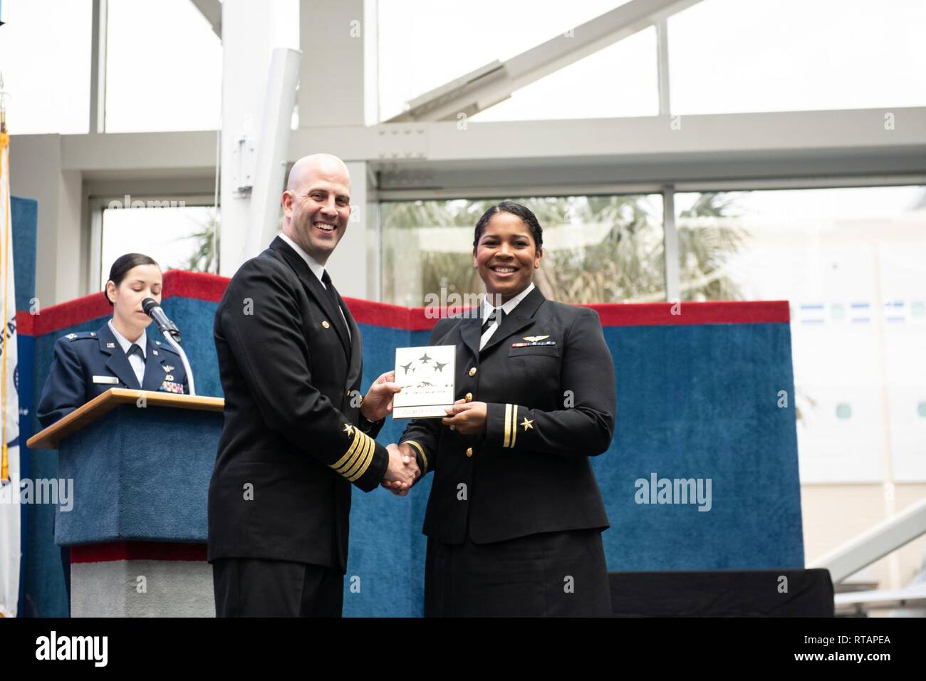 Navy Lt. j.g. Naomi Ngalle is presented the William B. McIlvaine III ...