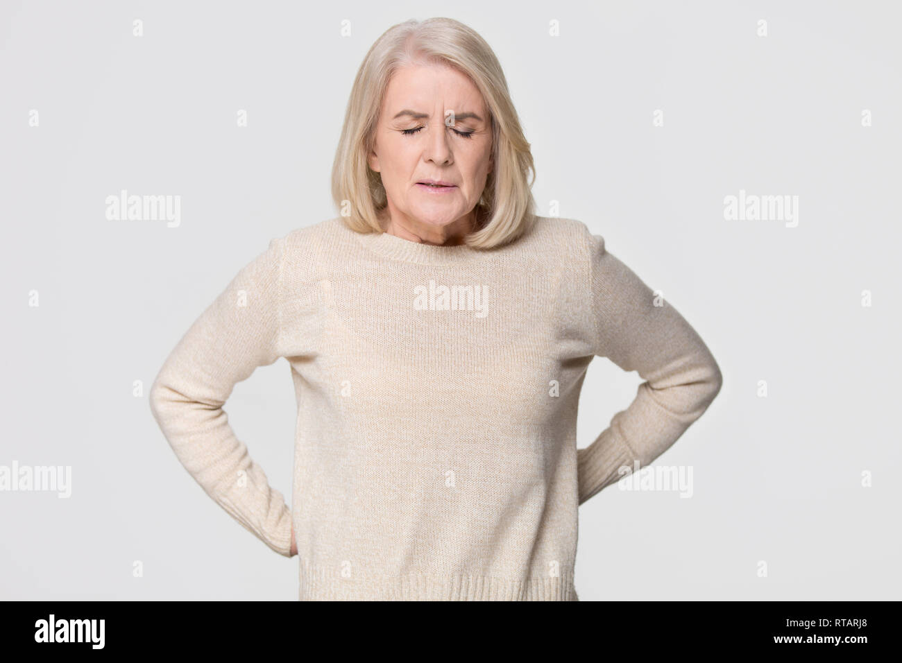 Upset old woman touching back feeling pain isolated on background Stock ...