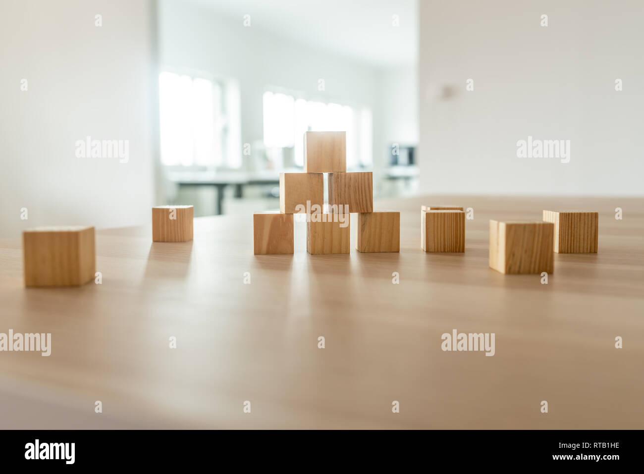 Wooden cubes positioned in a pyramid shape on office desk in a ...