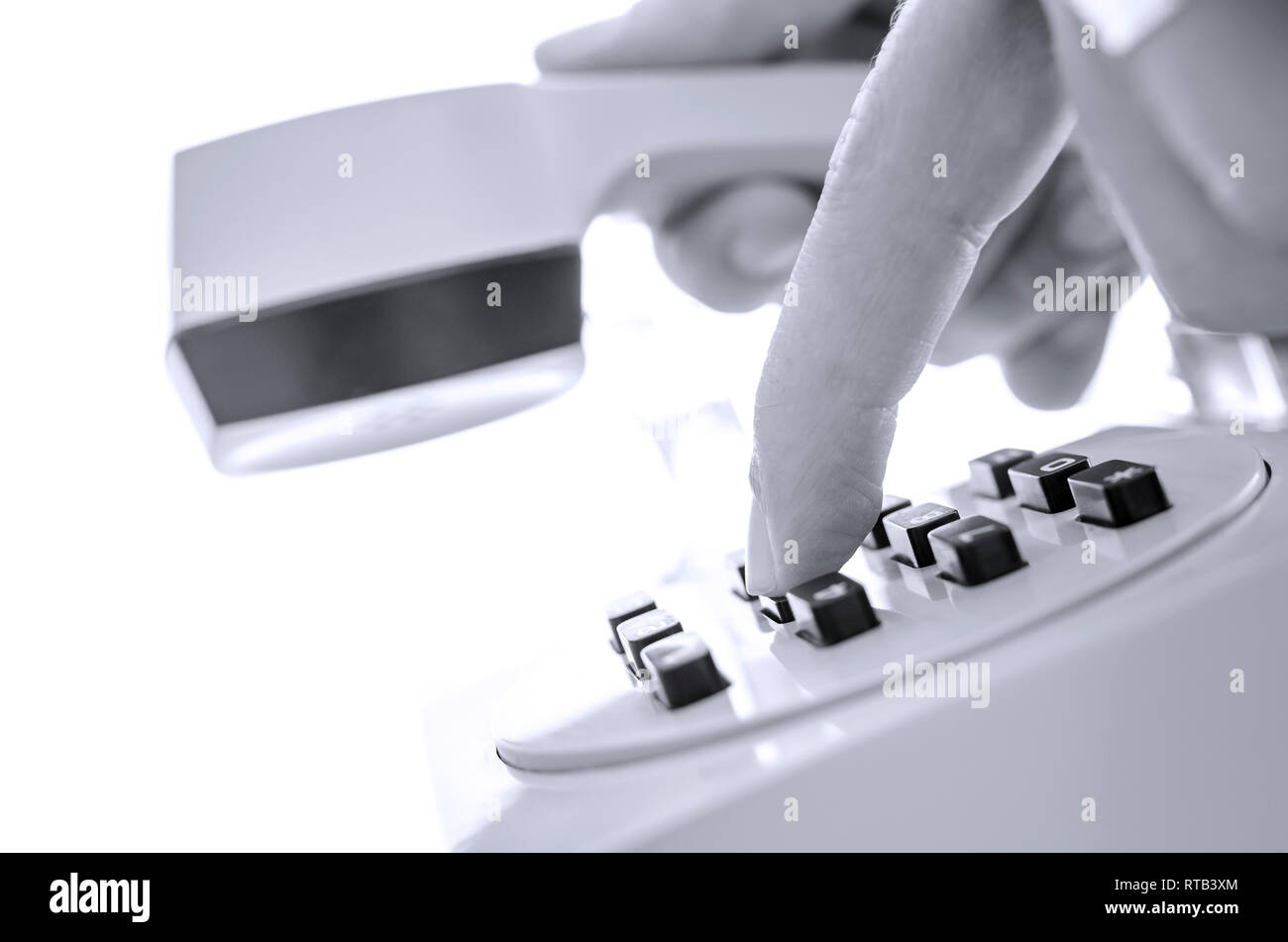 Side view of dialing a phone number on an outdated telephone with ...