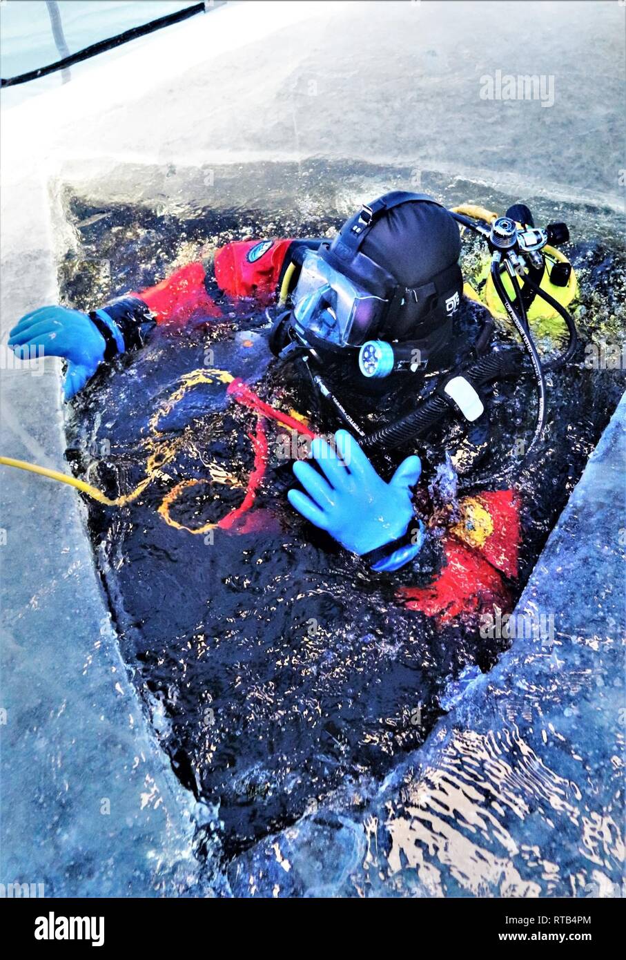 A firefighter wearing a full diving suit and related equipment treads ...