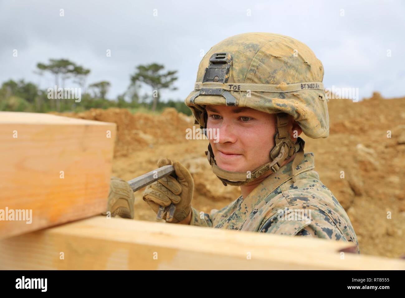Lance Cpl. Bryce Taft uses a crowbar to pry a 4x4 piece of wood from a ...