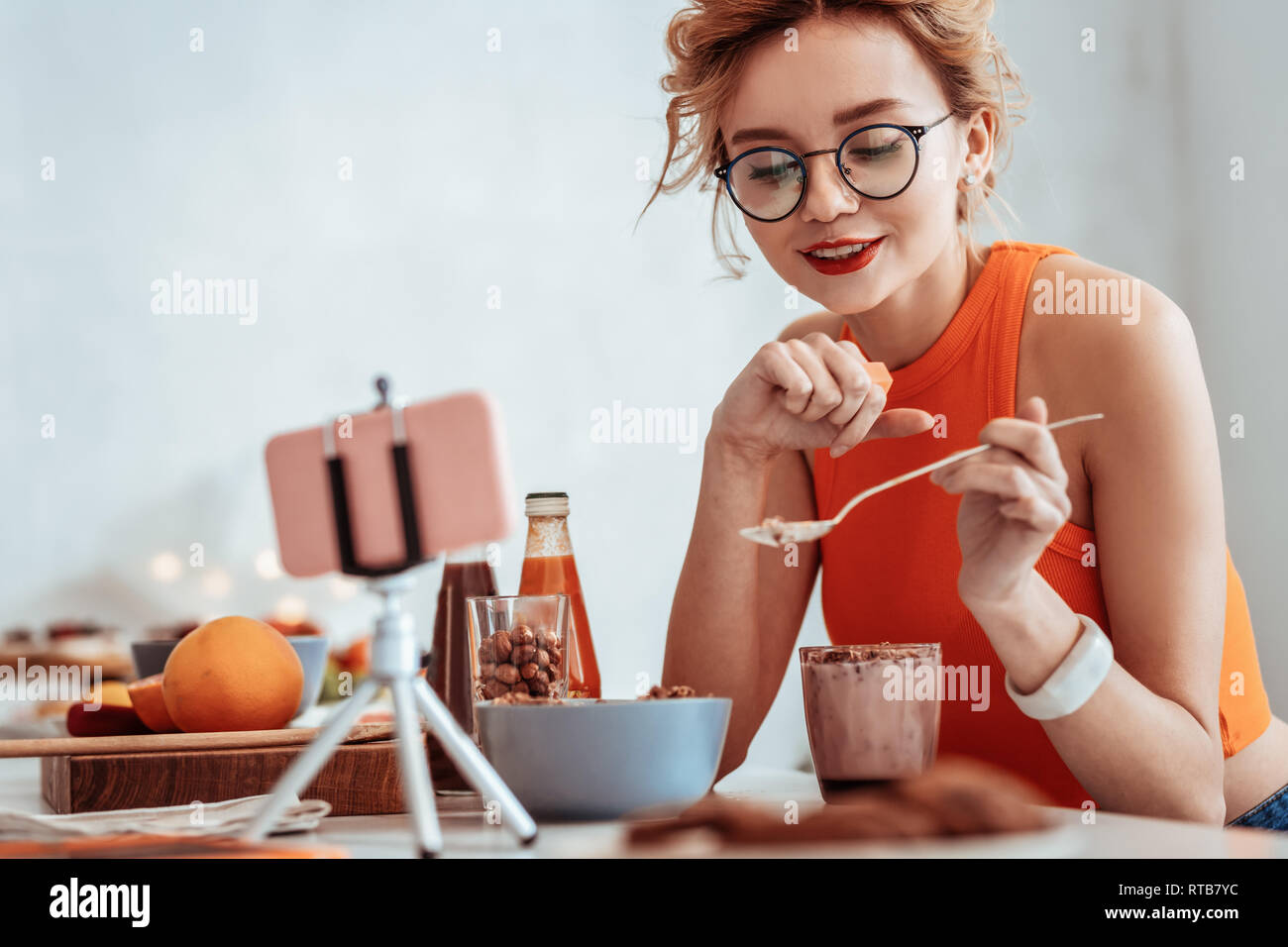 Positive good looking woman showing a spoon with muesli Stock Photo - Alamy