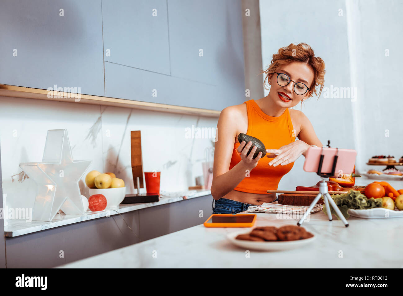 Positive slim young woman speaking about avocados Stock Photo - Alamy