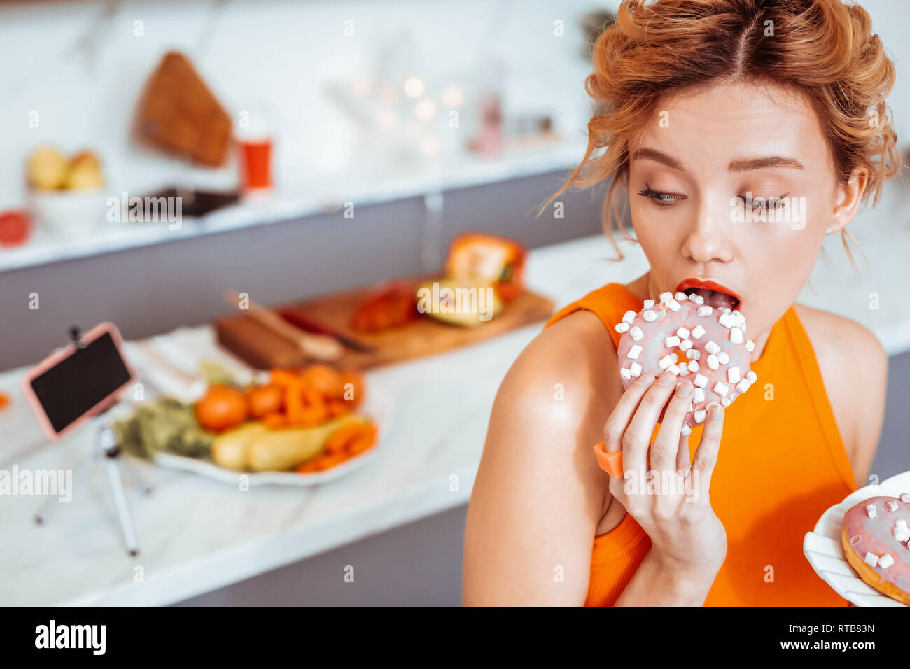 Beautiful pretty woman eating a delicious donut Stock Photo - Alamy