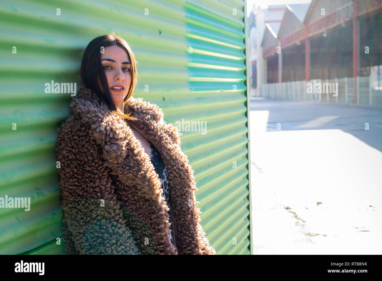 Stylish female near green wall Stock Photo - Alamy