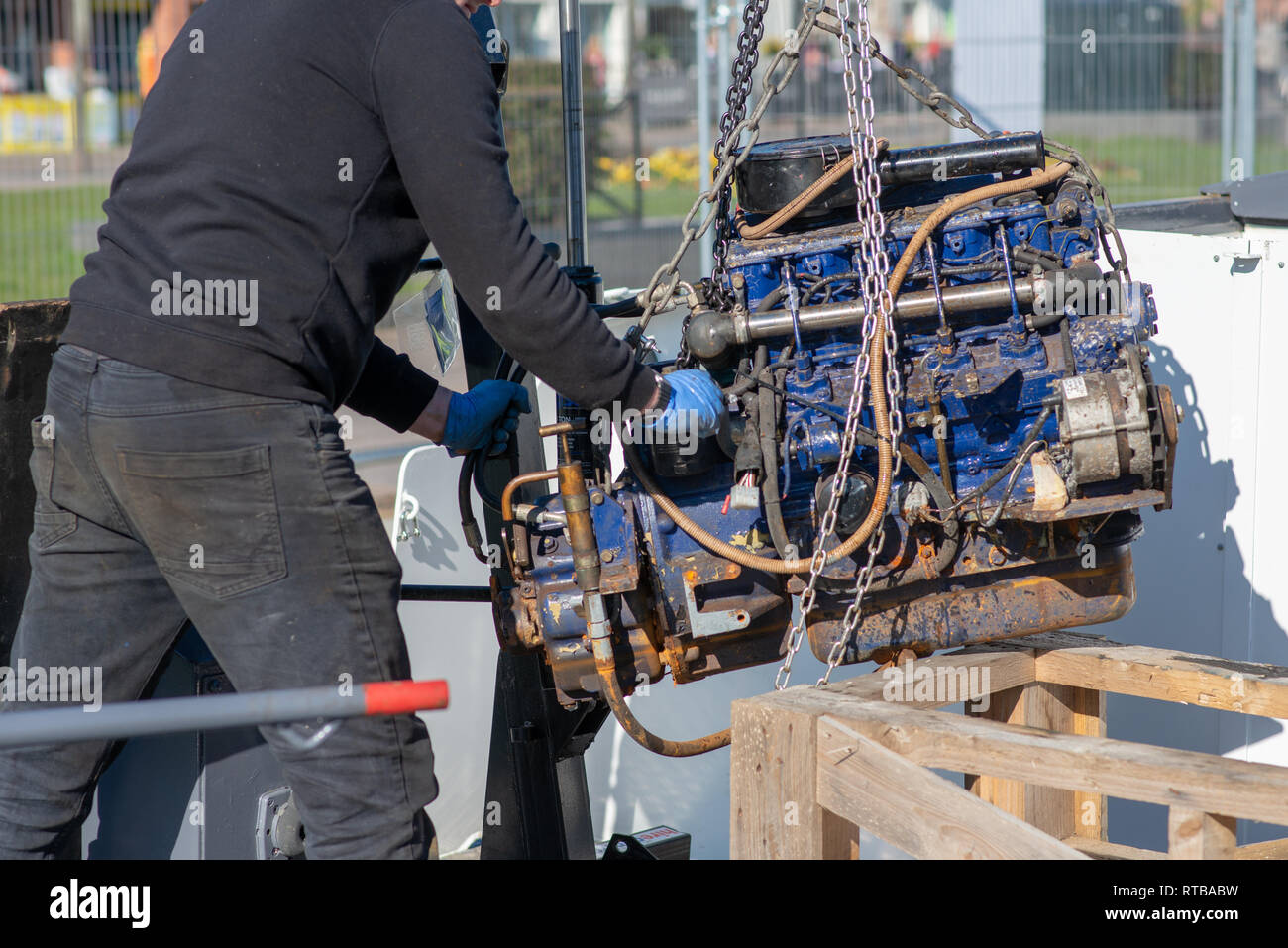 mechanic uses lifting equipment to remove engine block from boat Stock ...