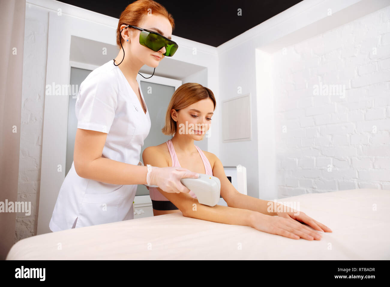 Red-haired depilatory master enjoying time with constant client Stock ...