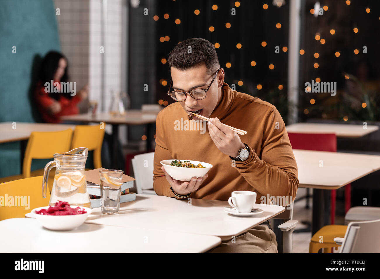 Customer sitting in restaurant and learning to eat a dish with Chinese ...