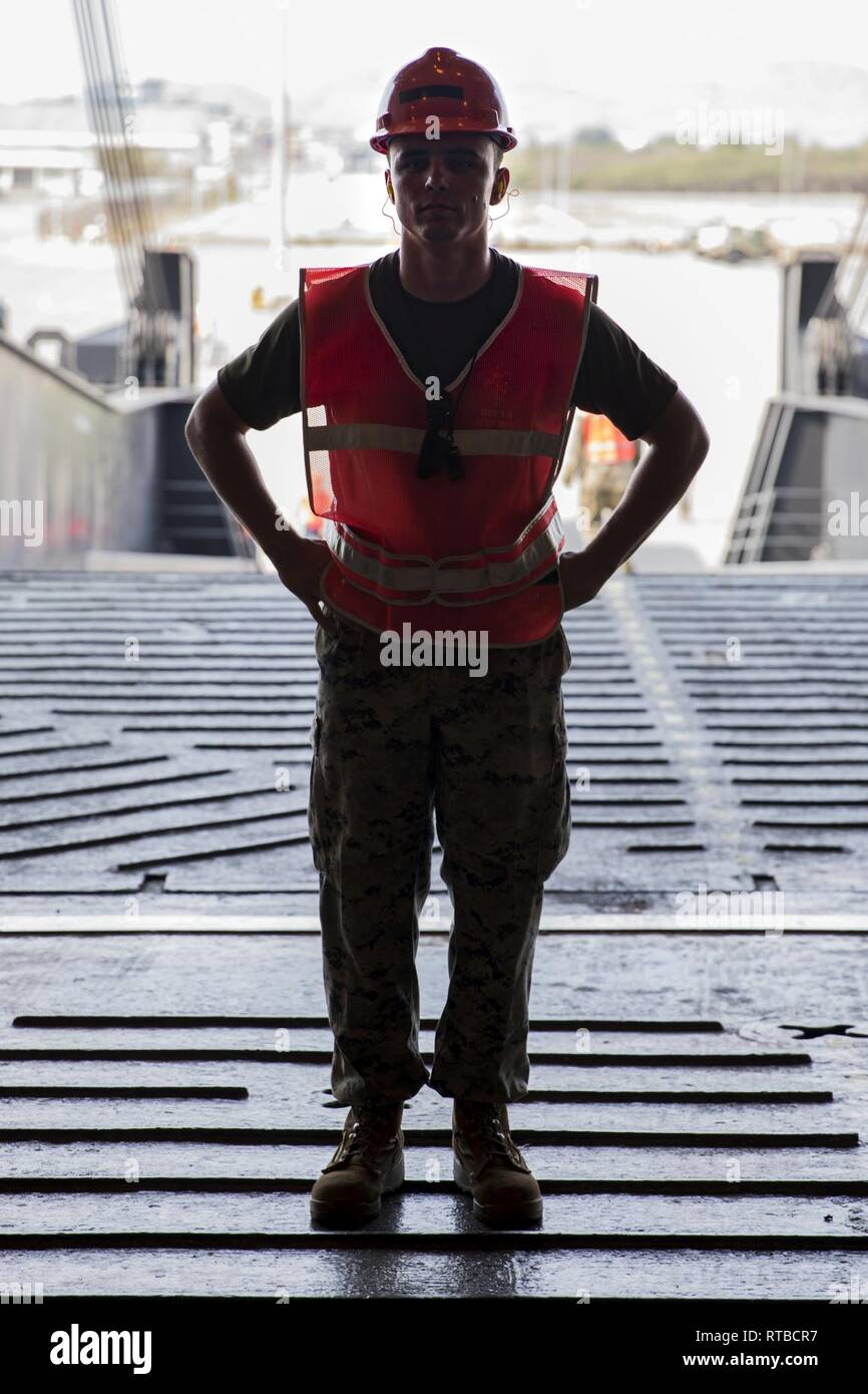 Cpl. David Vanpatton waits to ground guide a vehicle onto the ramp of ...