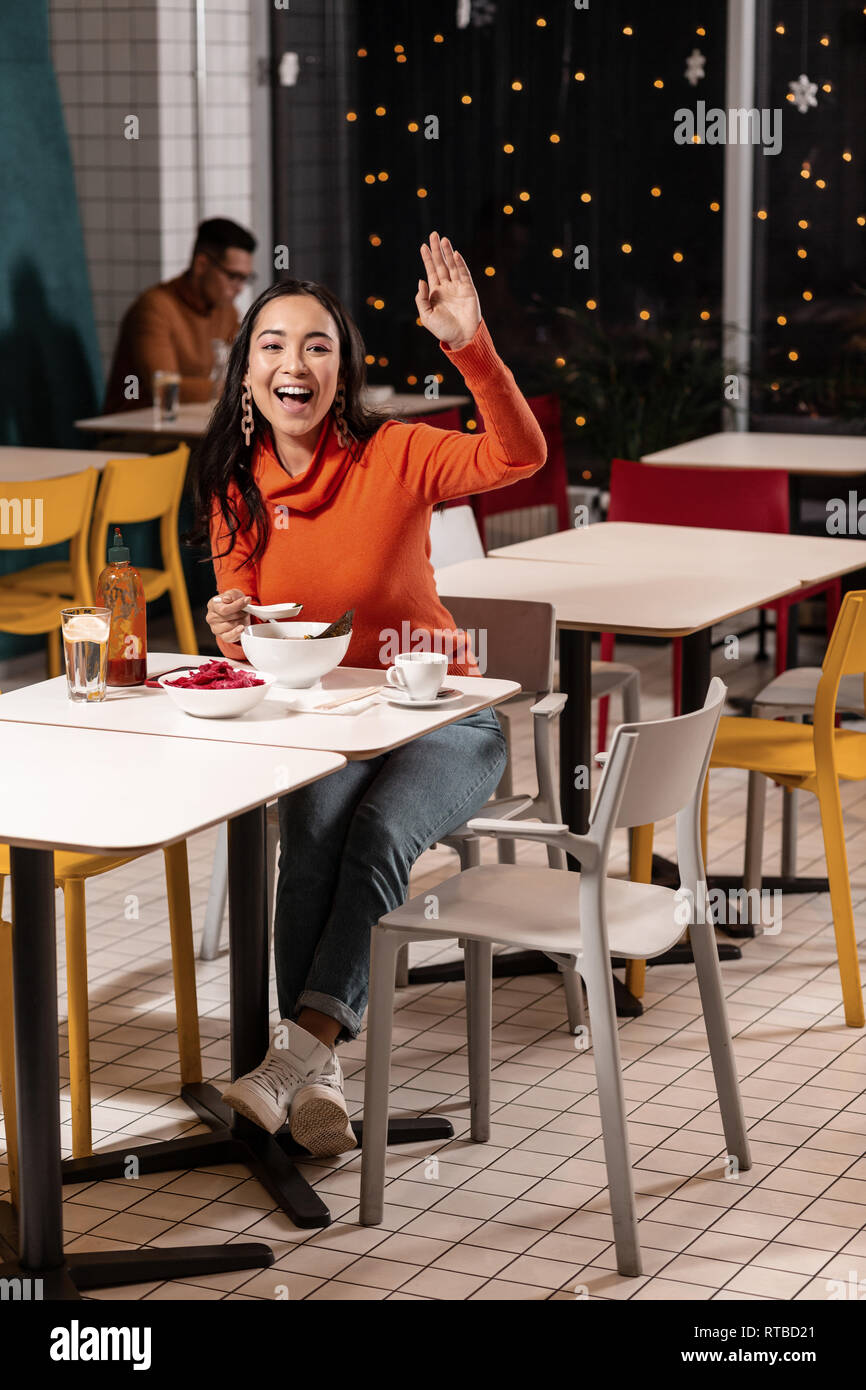 Young woman trying to attract the attention of a friend Stock Photo - Alamy