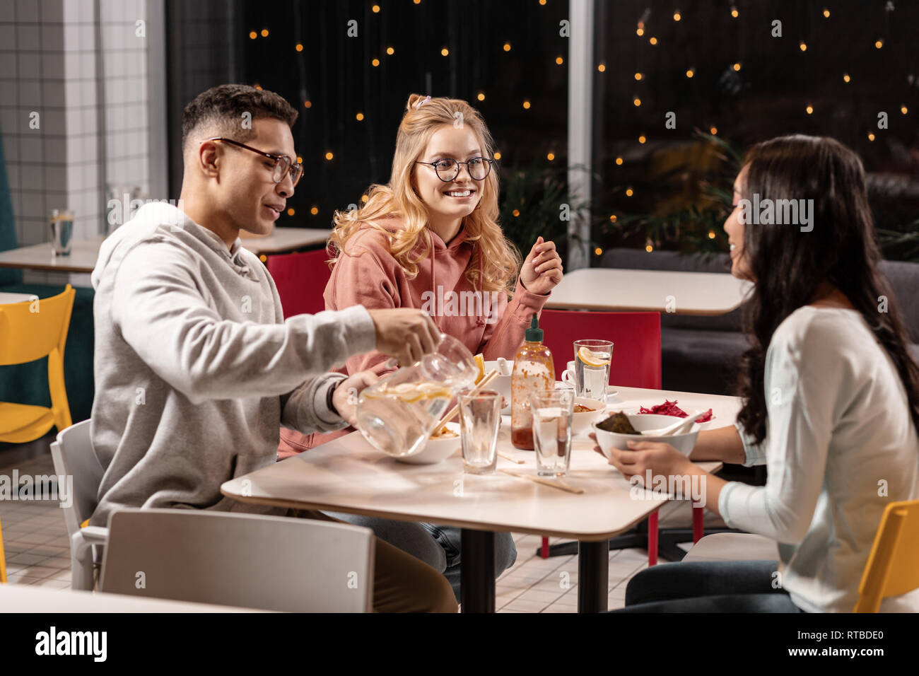 Company of students discusses previous day in university cafe Stock ...