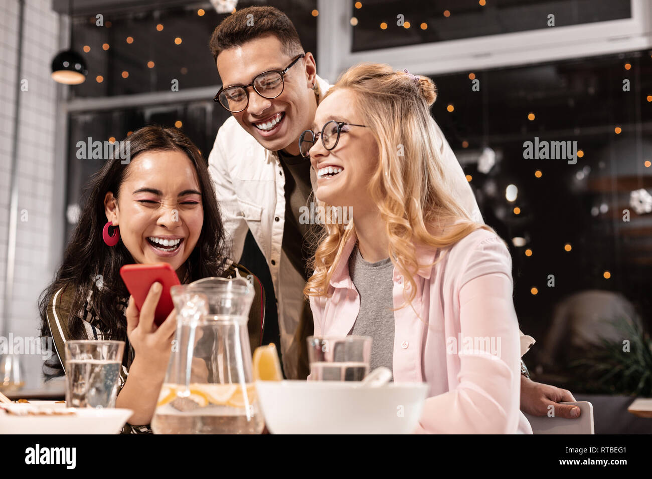 Multiracial company-of-three remembering something pleasant and ...