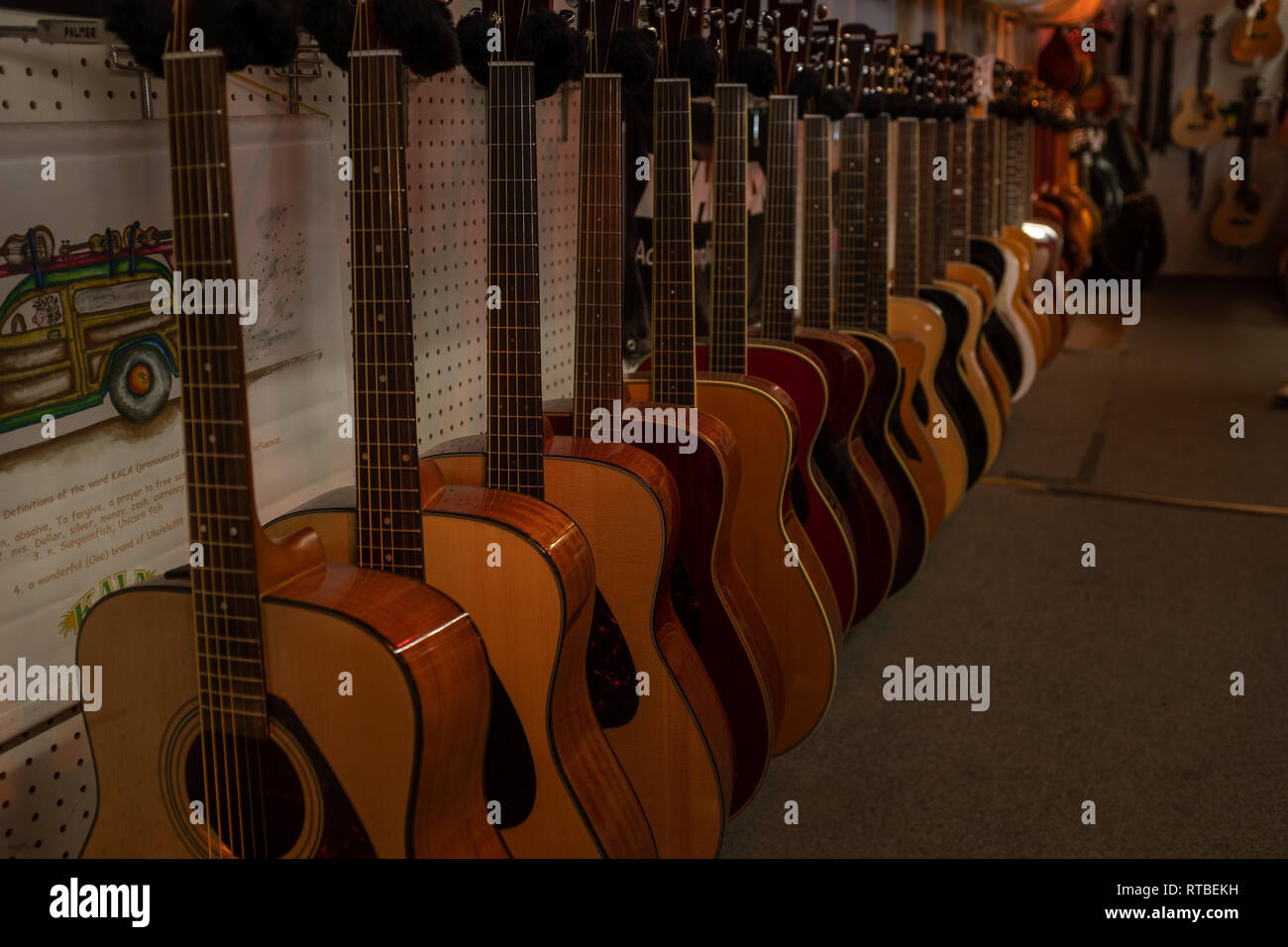 A row of acoustic guitars for sale of various colours Stock Photo - Alamy