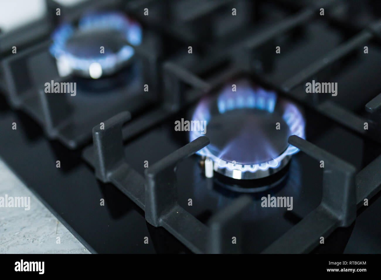 Cooktop with burning gas ring. Gas cooker with blue flames. Tinted ...