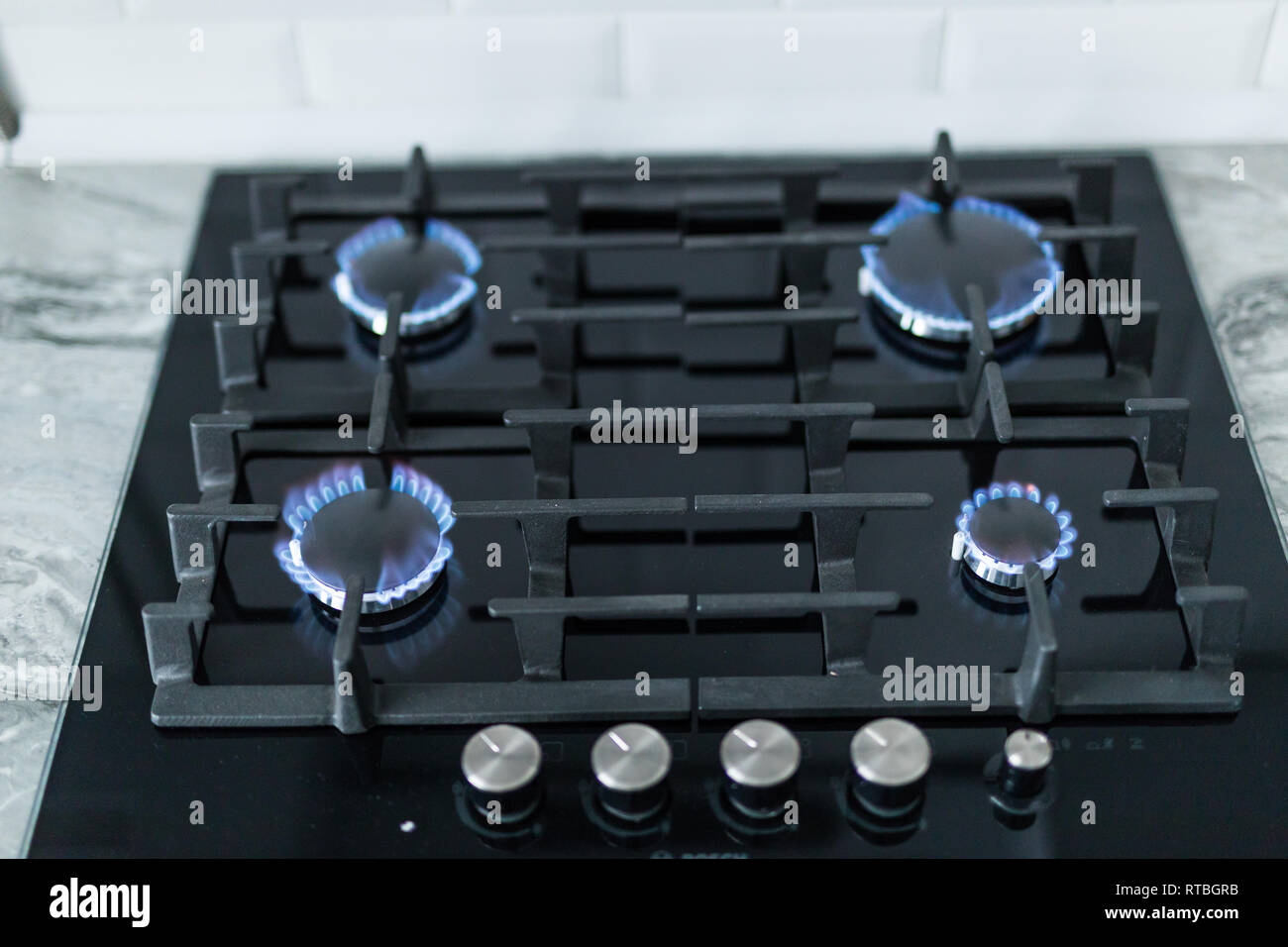 Cooktop with burning gas ring. Gas cooker with blue flames. Tinted ...