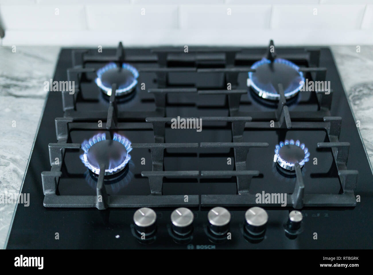 Cooktop with burning gas ring. Gas cooker with blue flames. Tinted ...