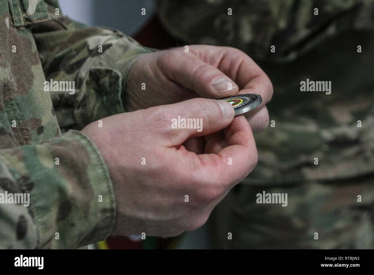 A Soldier holds a 184th Sustainment Command coin presented for ...