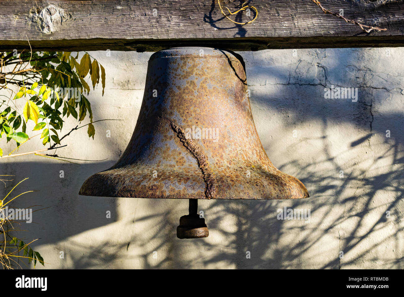 Old and rusted monastery bell suspended on a wooden beam, Monterey ...