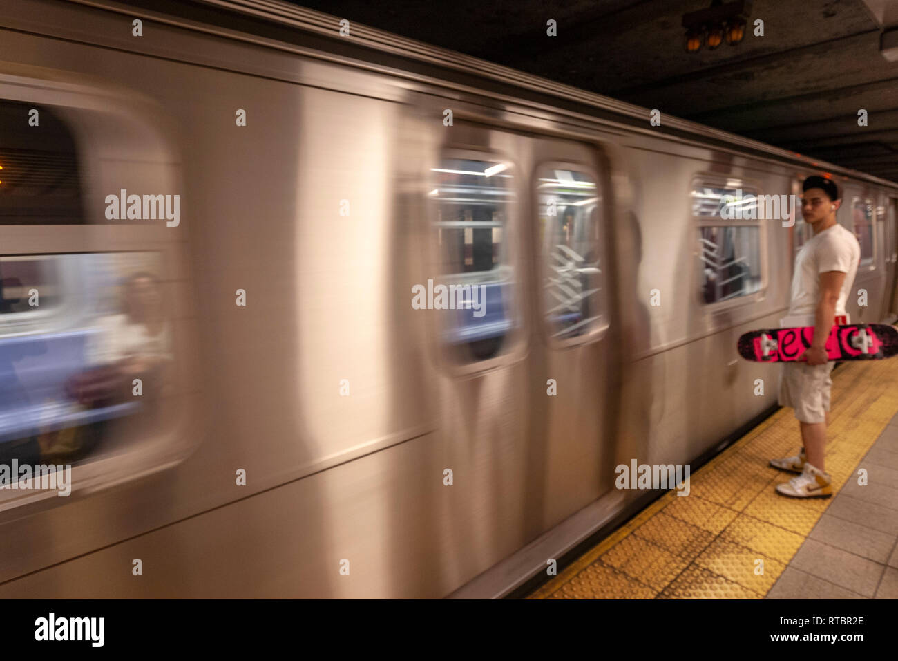 Young boy with skateboard in the Canal Street subway, Manhattan, New ...